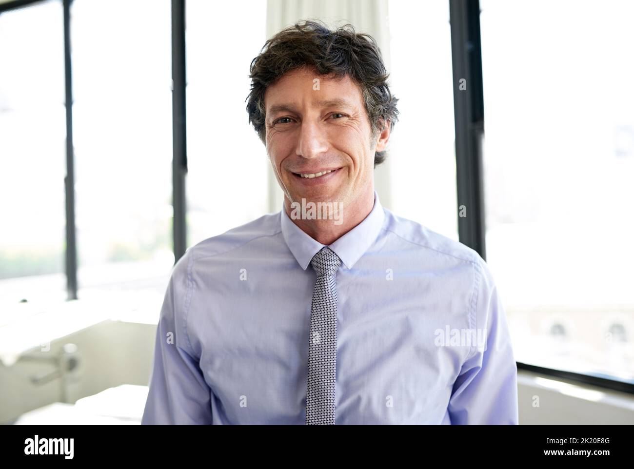 Focused on success. Portrait of a businessman in an office with large ...