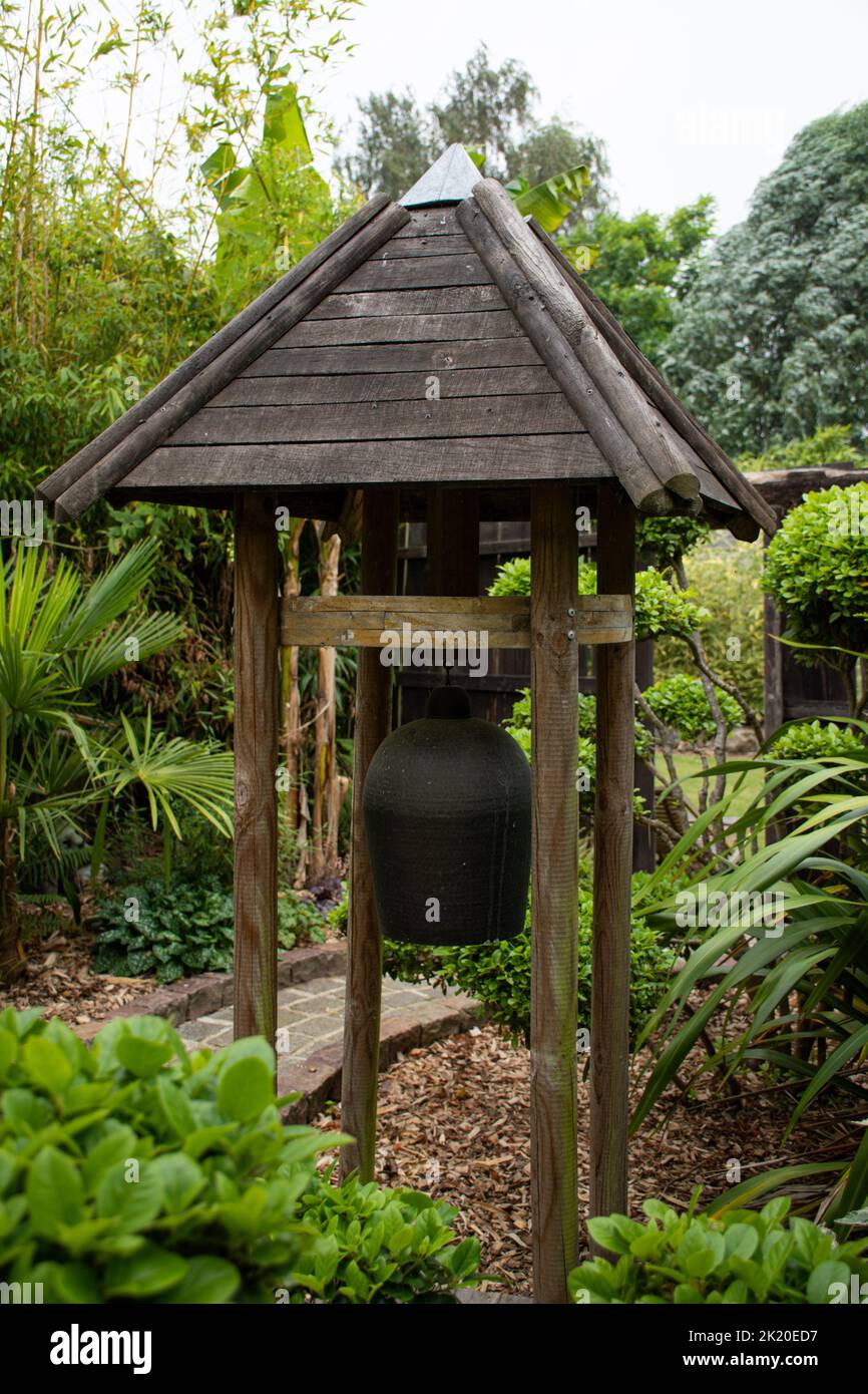 A vertical closeup of a brown, wooden water well in the garden outdoors ...