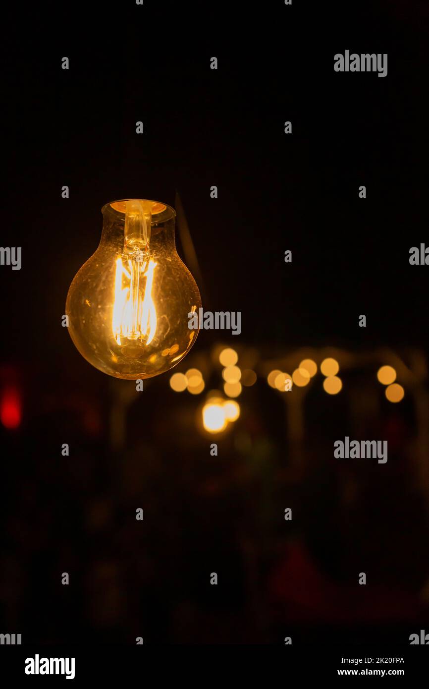 A vertical shot of the light bulbs in the dark Stock Photo - Alamy