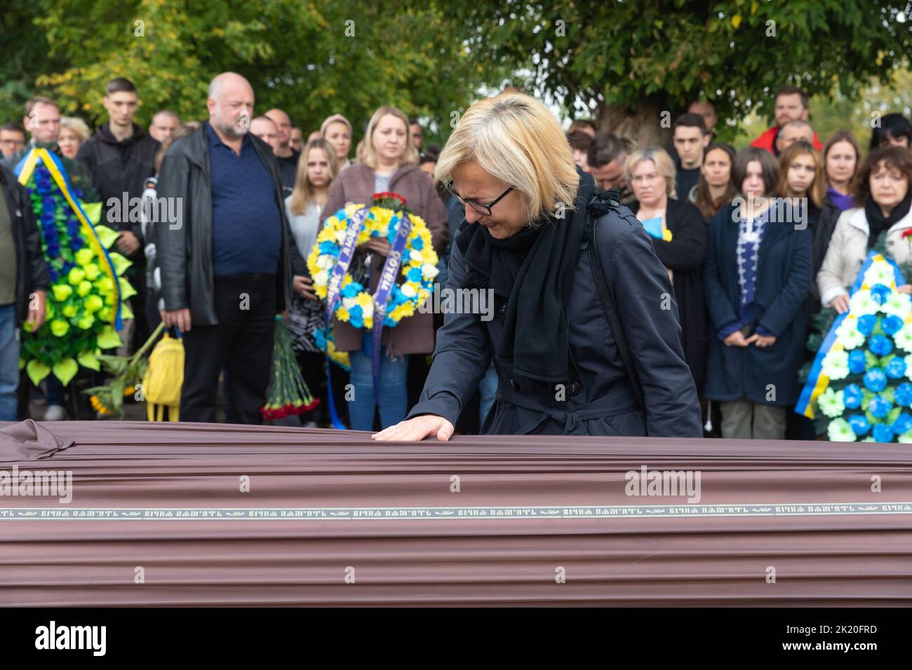 A mourner weeps while touching on the coffin of the deceased hero ...