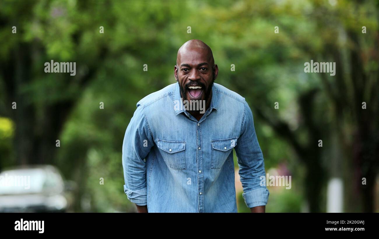 African man dancing in happiness outside smiling Stock Photo - Alamy