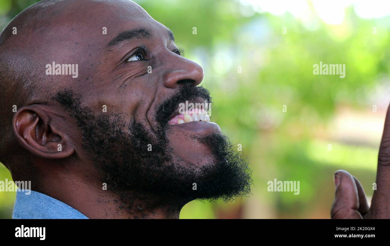 African man feeling grateful. Person praying to God smiling looking at ...