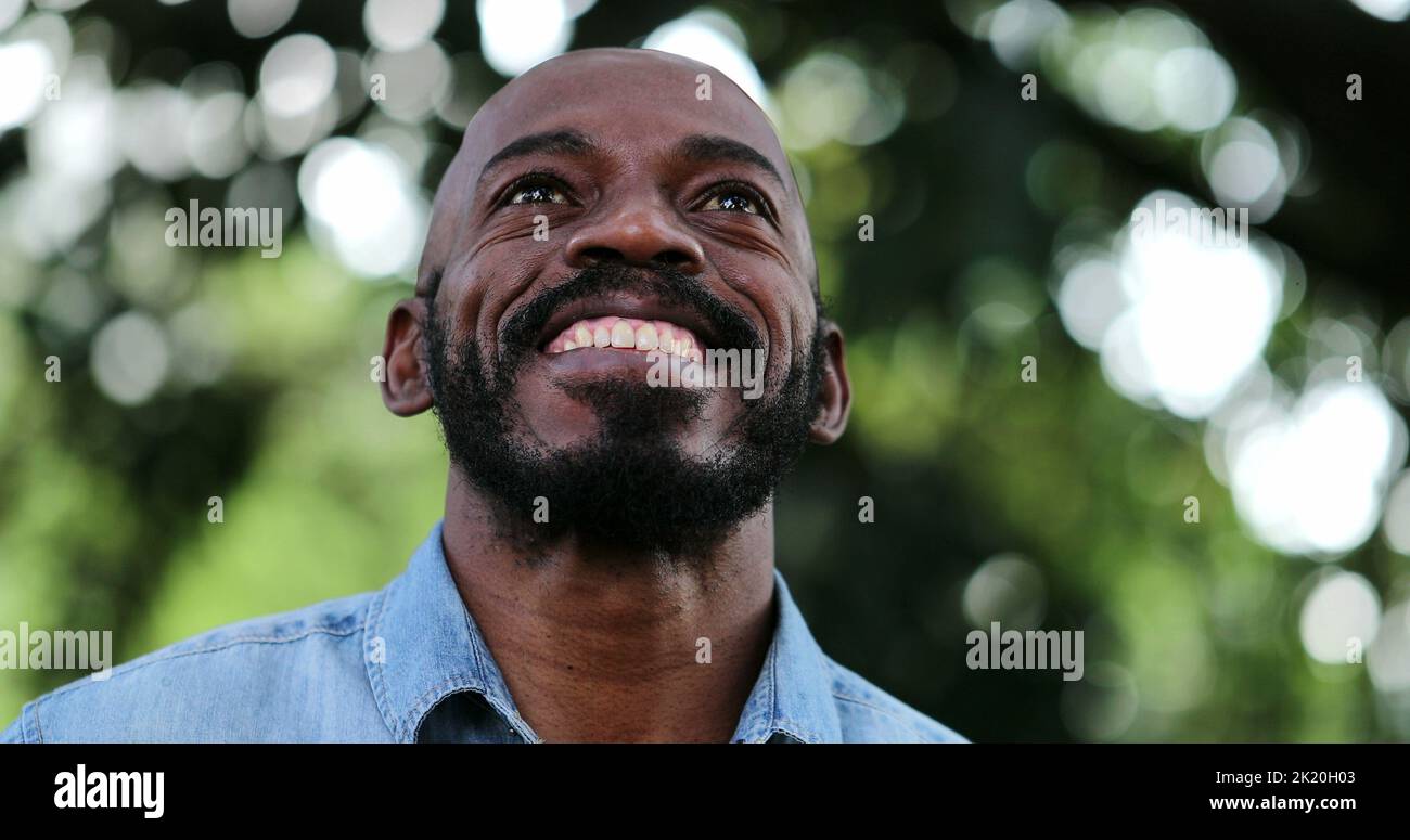 African man taking a deep breath and opening eyes smiling feeling free ...