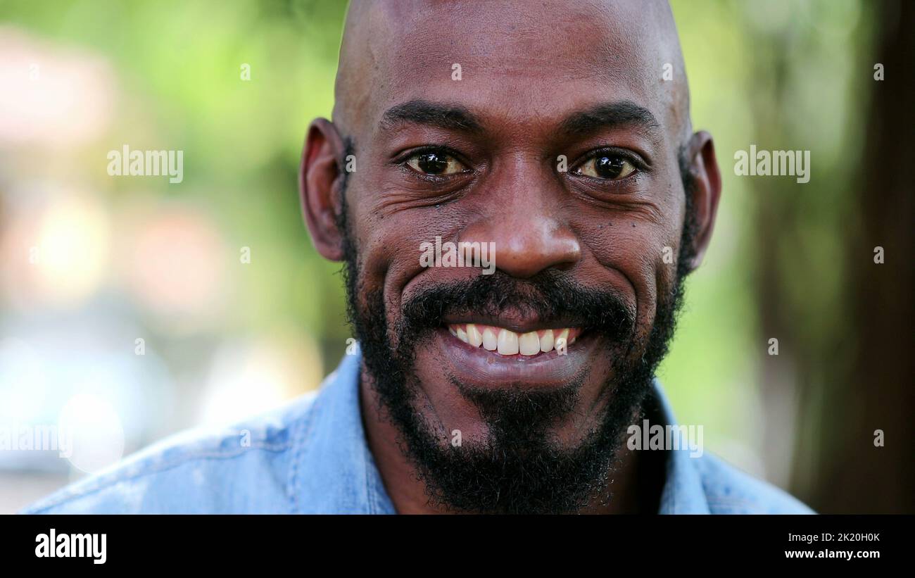 African man smiling standing outside. Black person portrait face close ...