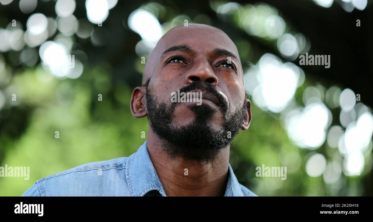 African man taking a deep breath and opening eyes smiling feeling free ...