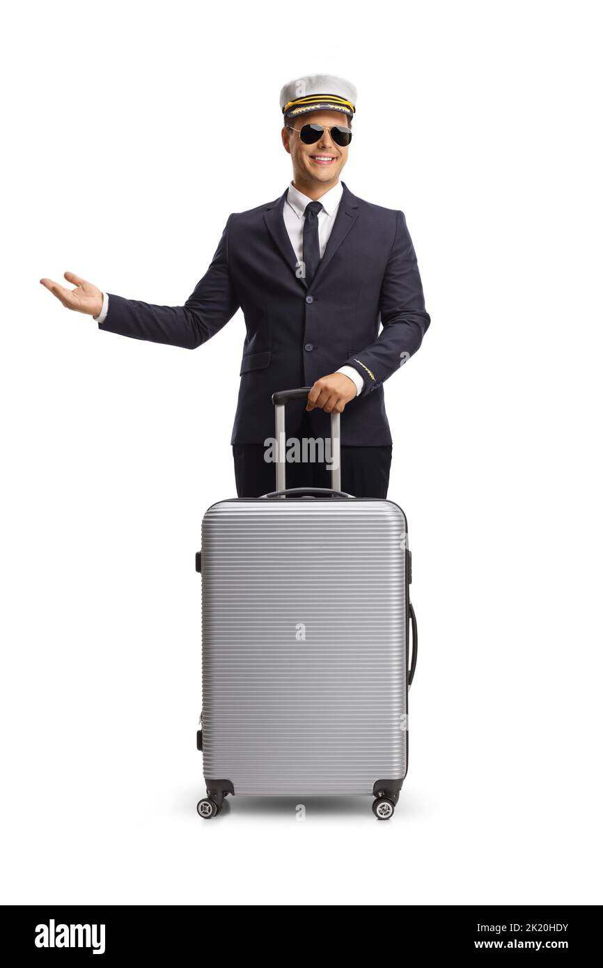 Young pilot standing with a suitcase and pointing with hand isolated on ...