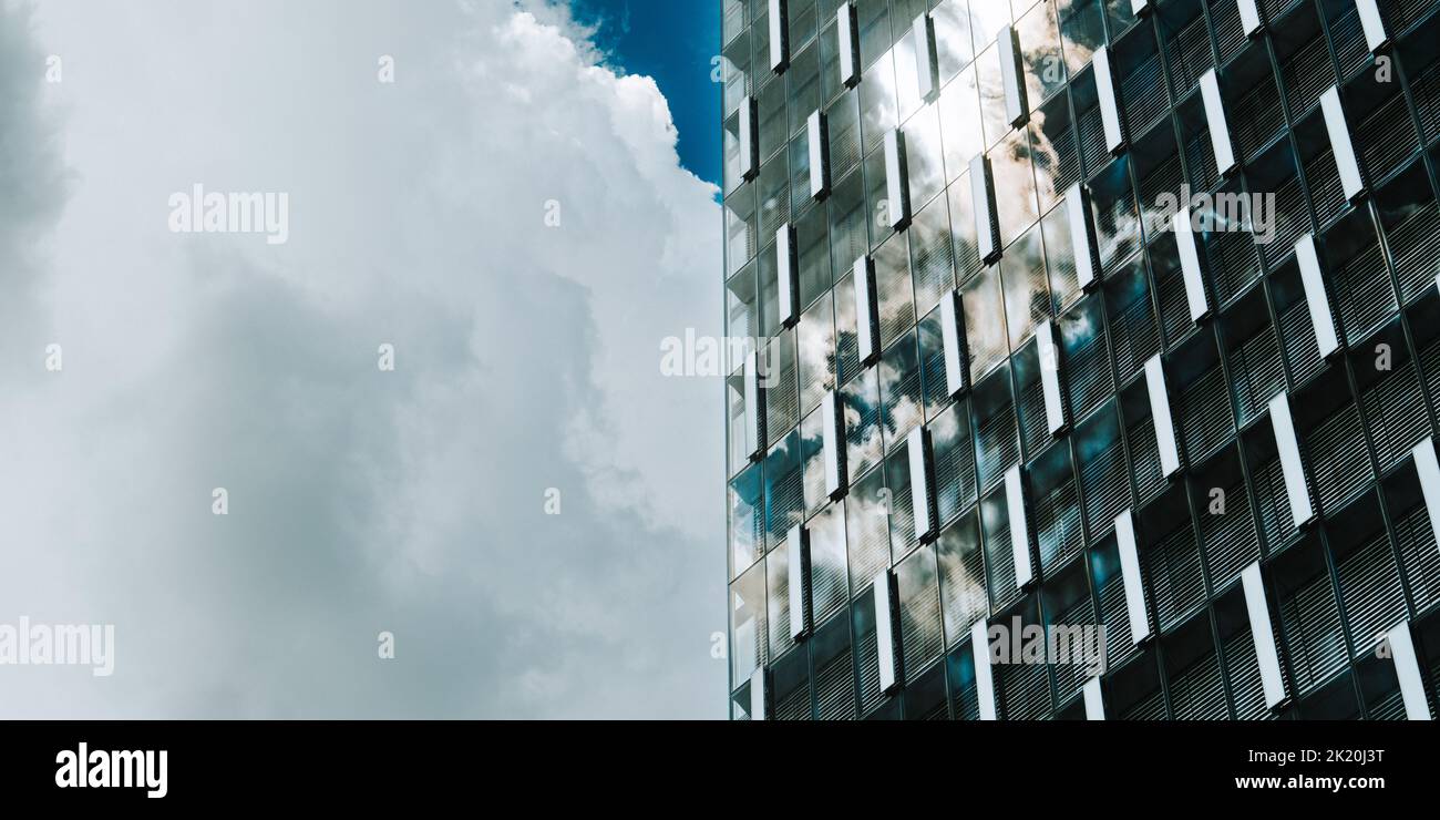 A low angle shot of a building glass with a cloudy sky Stock Photo - Alamy