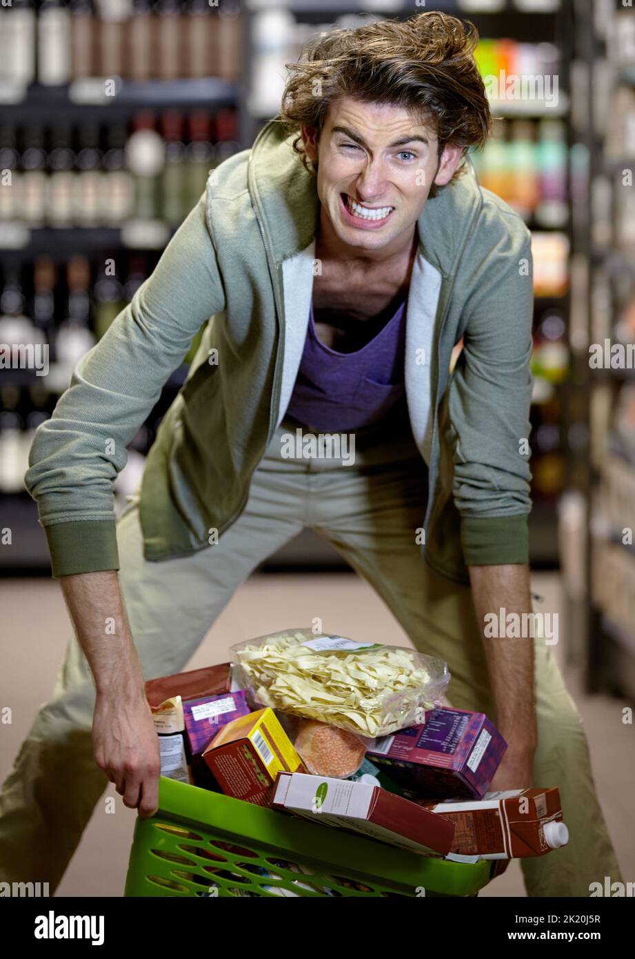 This is heavy. A young man struggling to pick up his basket full of ...