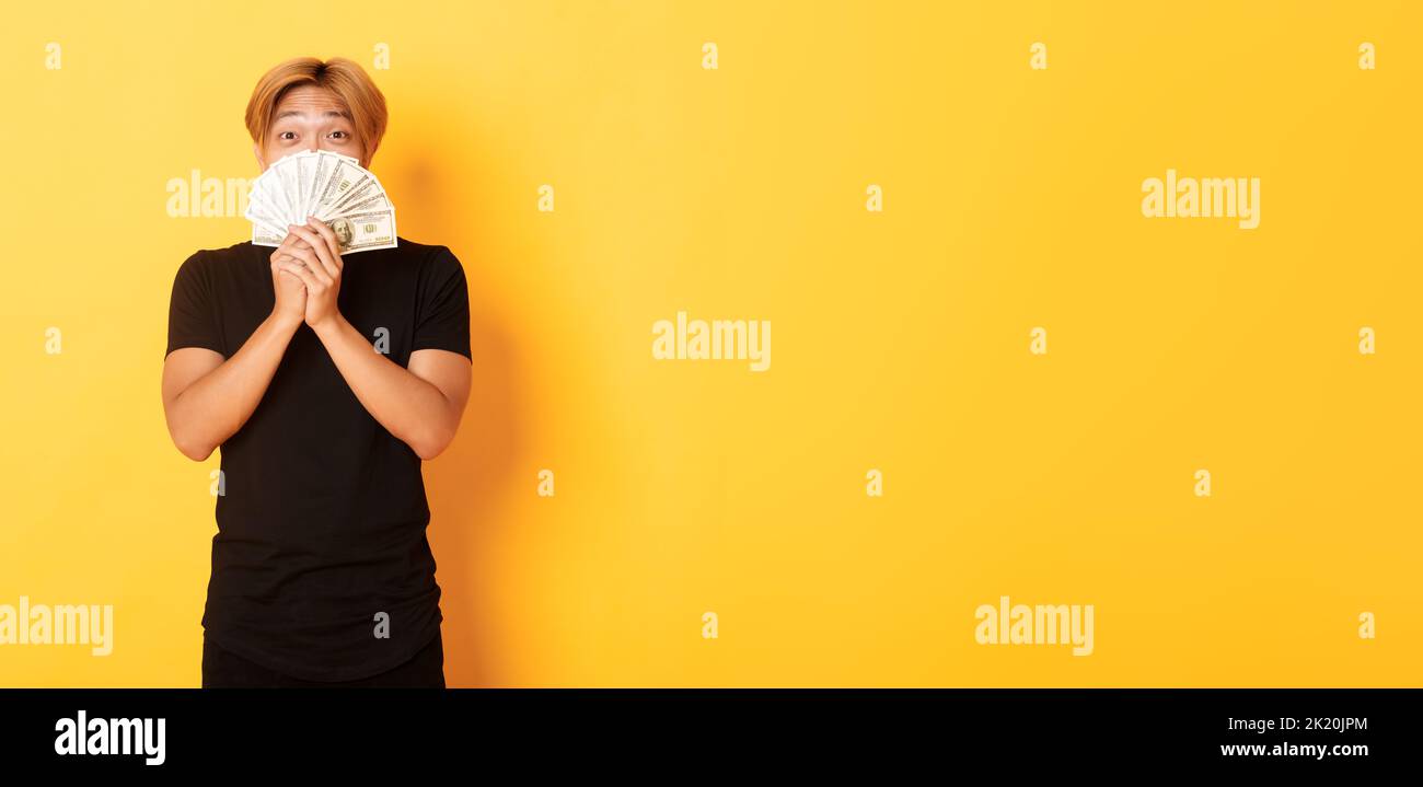 Excited lucky blond asian guy rejoicing from winning cash, holding ...