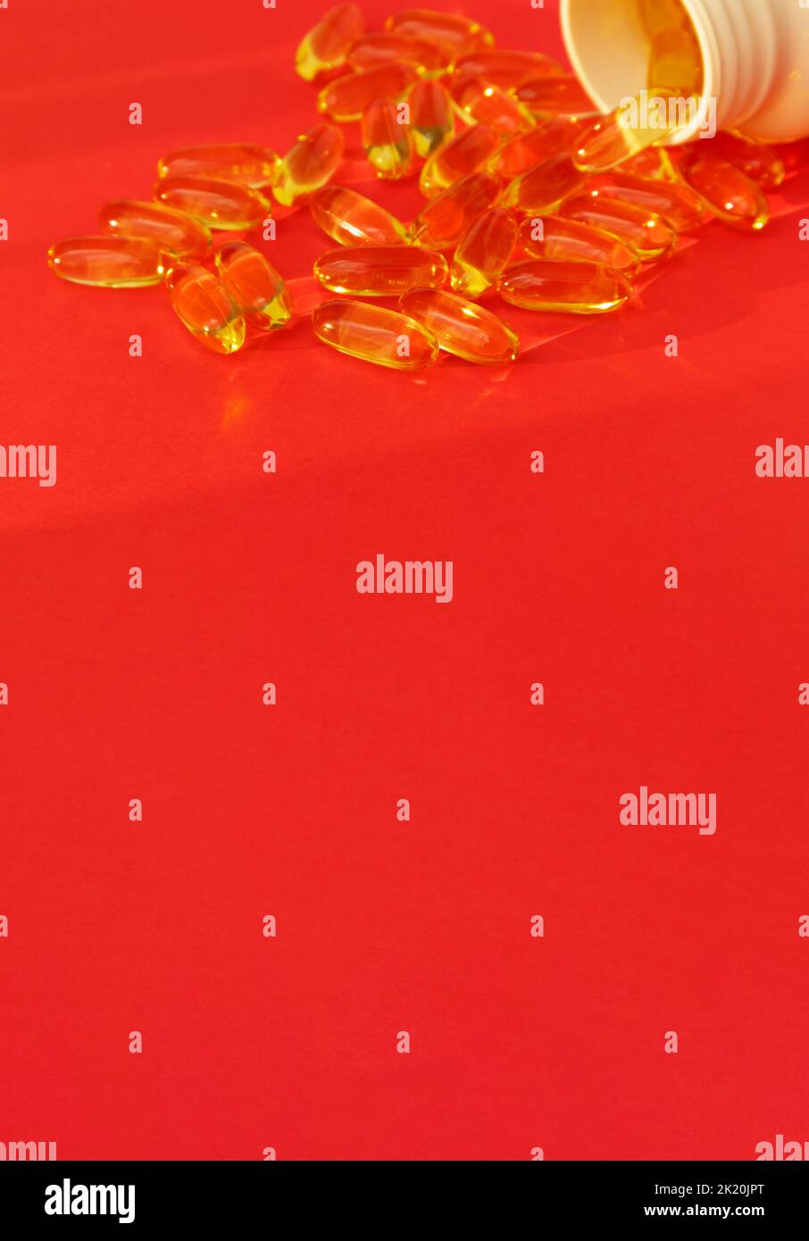 Fish oil pills. Omega 3 gel capsules on red background Stock Photo - Alamy