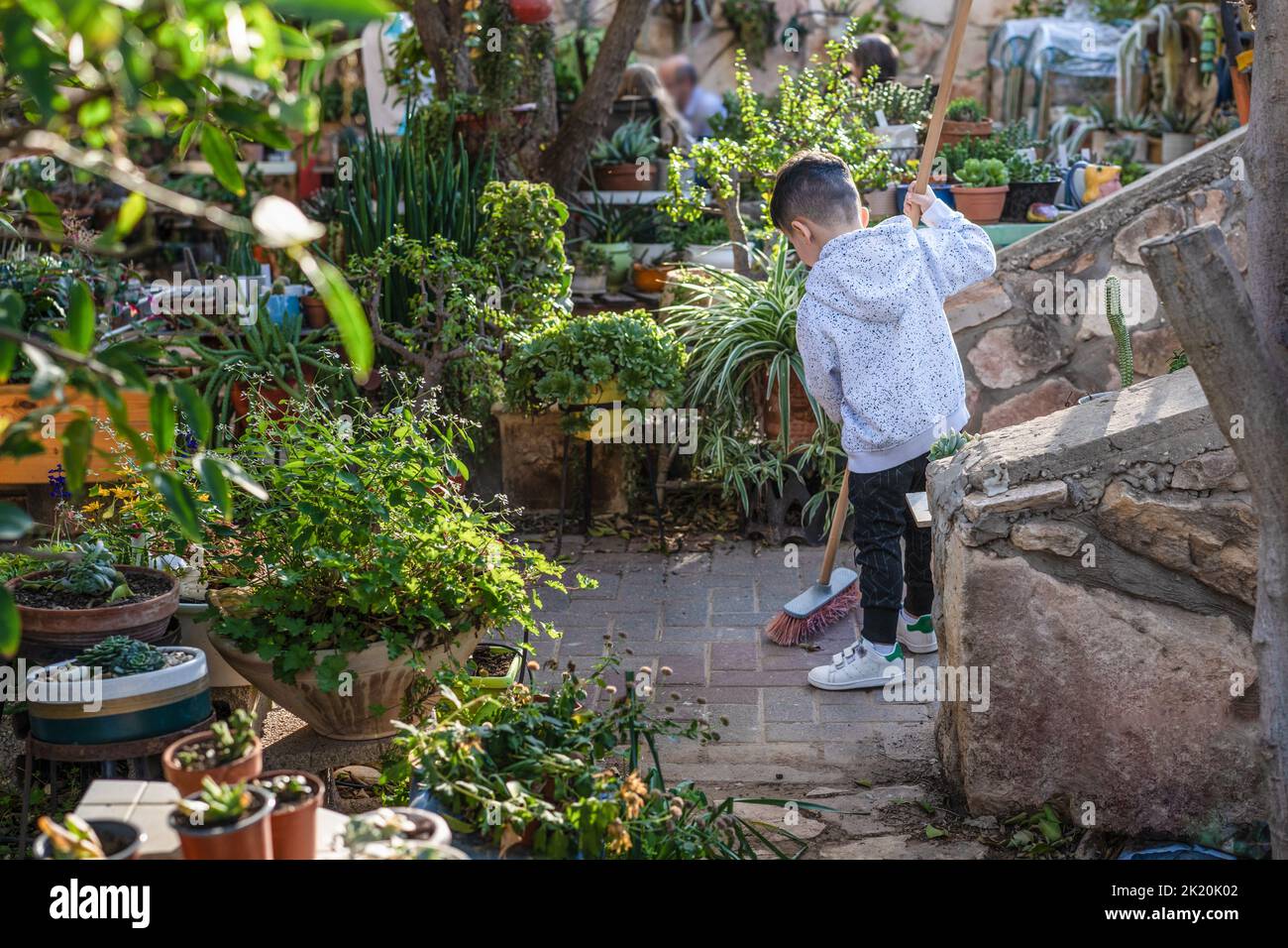 Cute Little Child Sweeping with Broom at Beautiful Garden Stock Photo ...