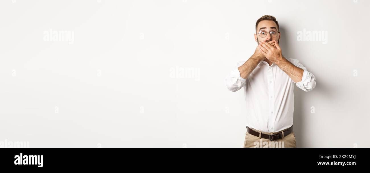Shocked man gasping and looking at something in awe, covering mouth ...