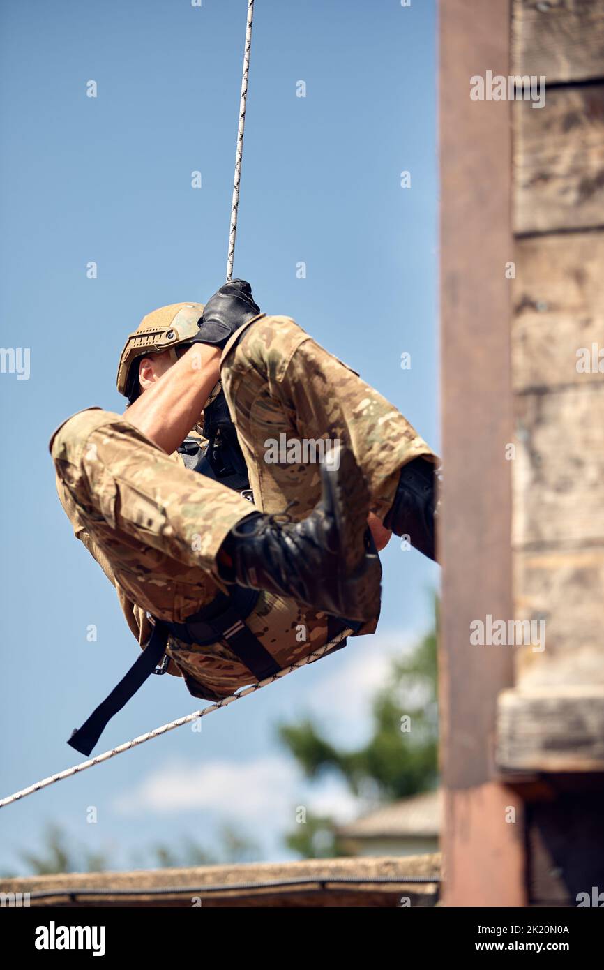 Soldier training rappel with rope. Military man does hanging on ...
