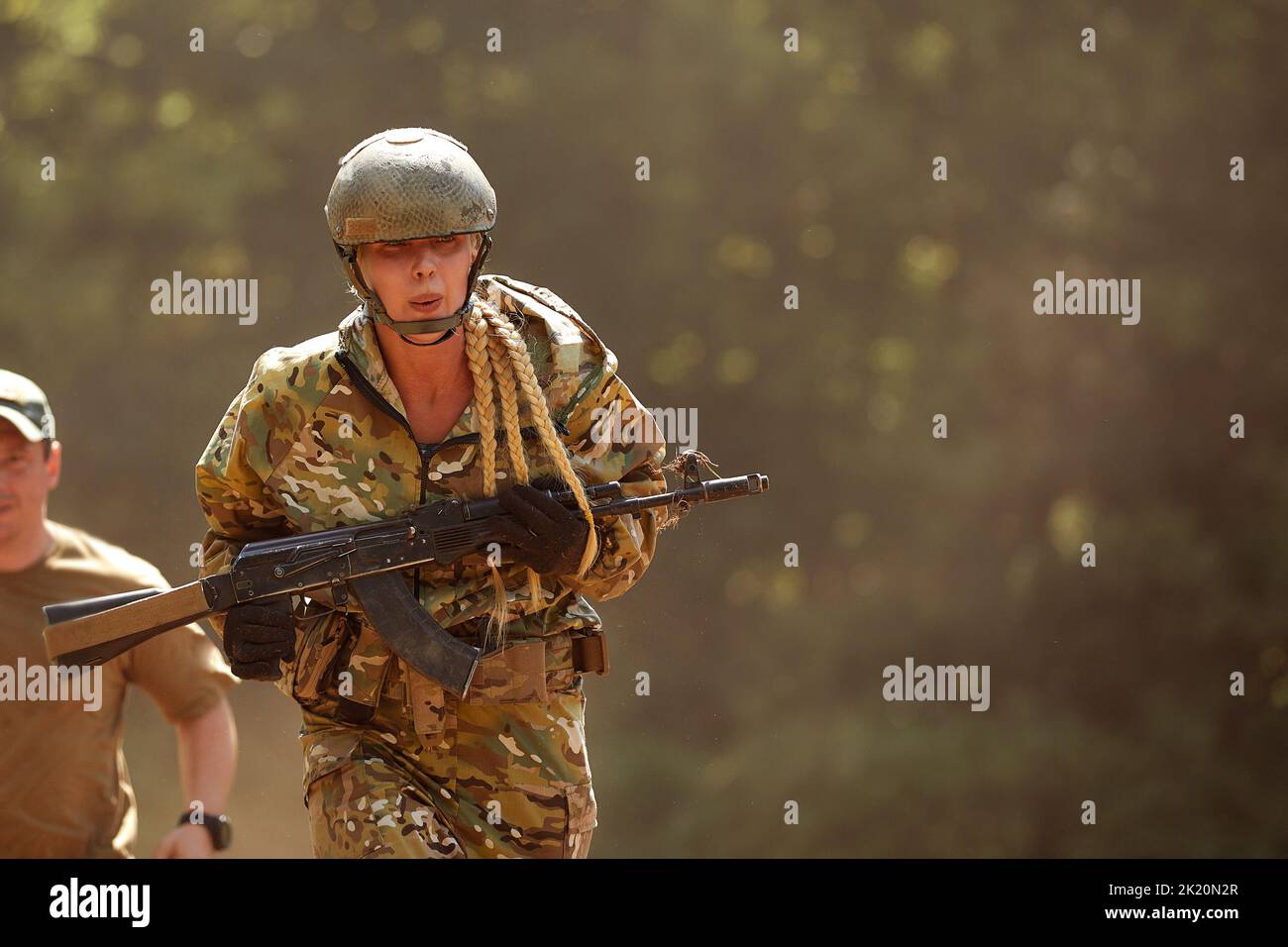 Portrait of fit military female holding weapon rifle in hands in river ...