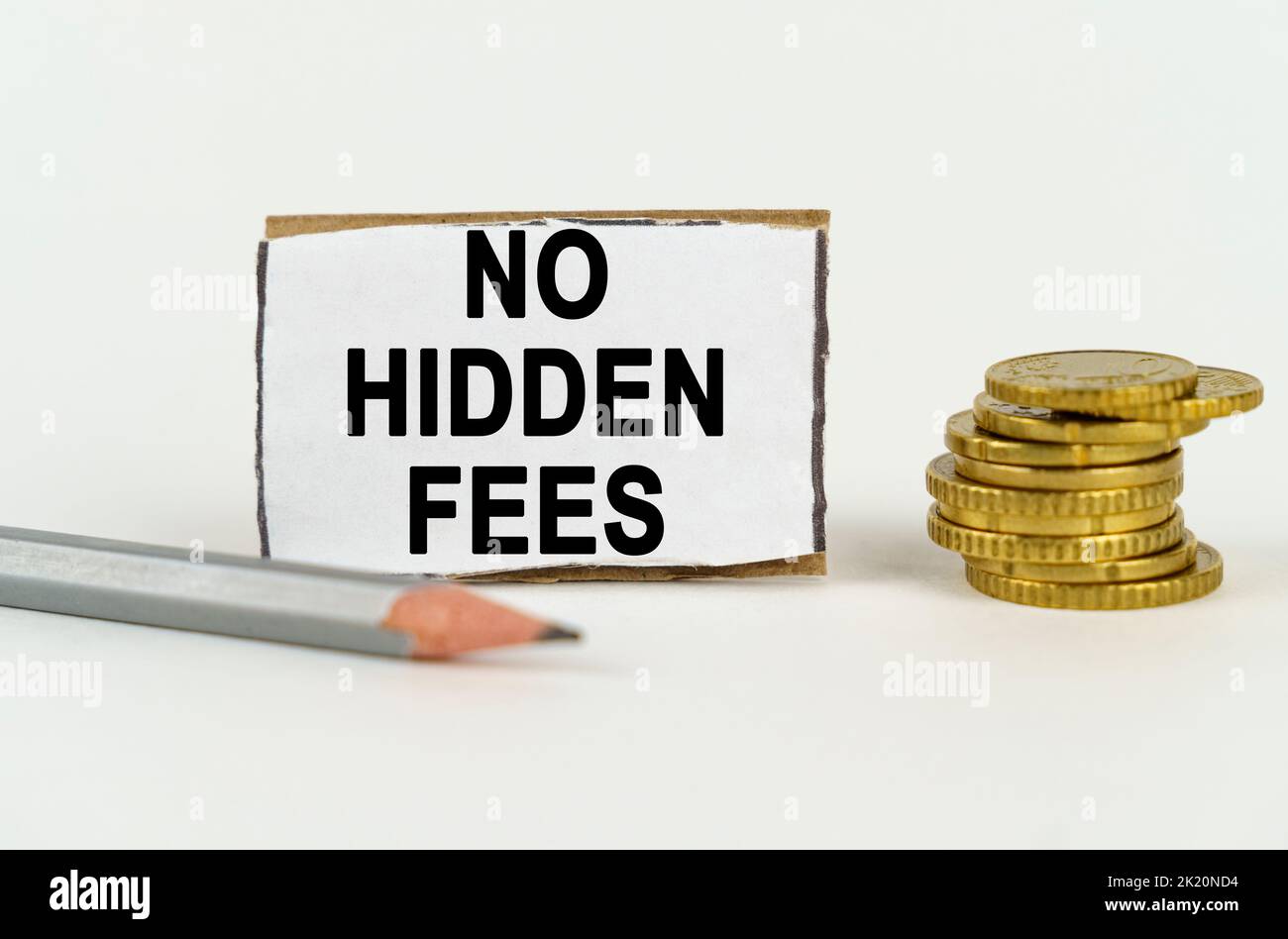 Business concept. On a white background, a pencil, coins and a sign ...