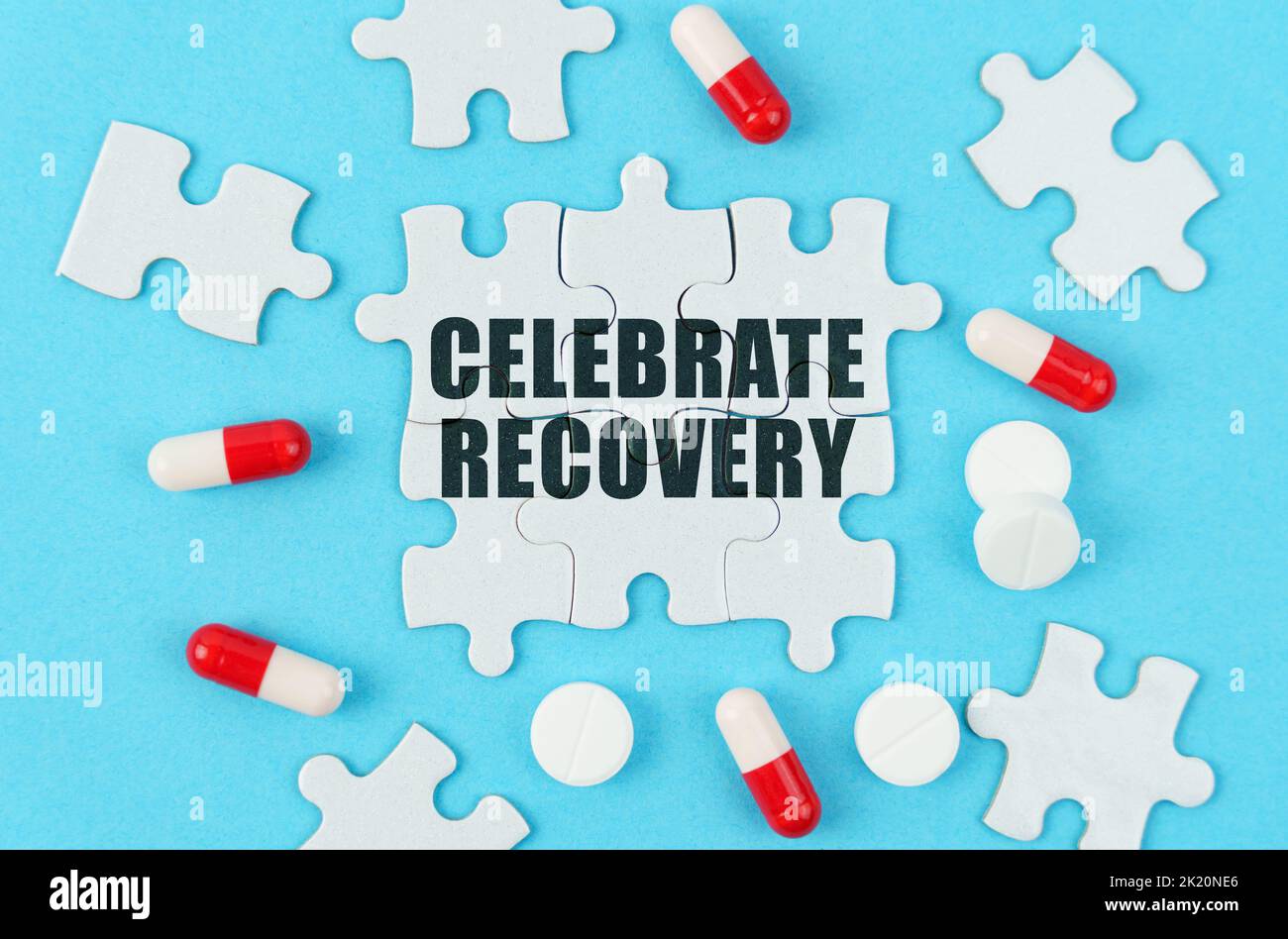 Medical concept. On a blue background, pills, capsules and puzzles with ...