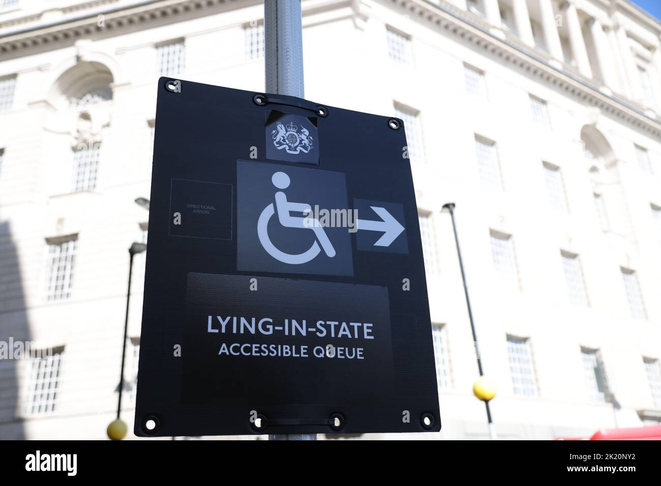 A sign for the Lying-in-State accessible queue and people have queued ...
