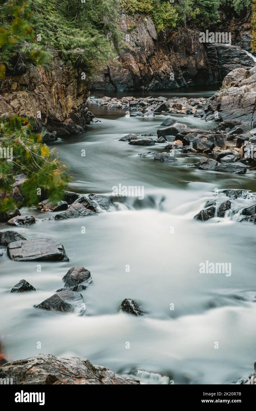 A Scenic view of a water cascade in long exposure effect flowing on ...