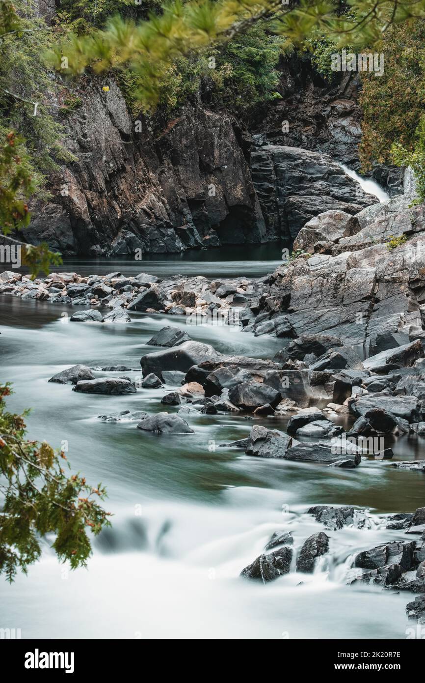 A Scenic view of a water cascade in long exposure effect flowing on ...