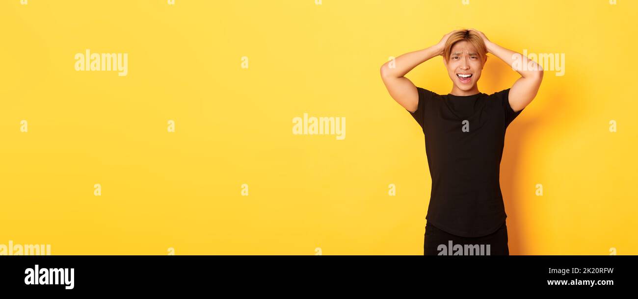 Portrait of young asian guy panicking, looking anxious and upset ...