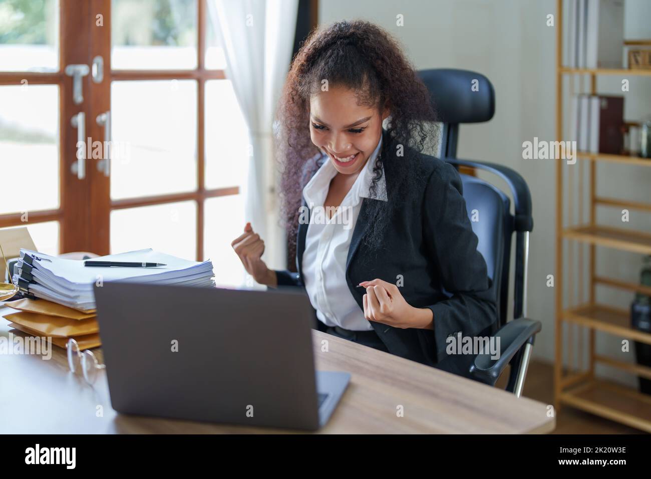 female African Americans lawyer showing joy while using a computer ...