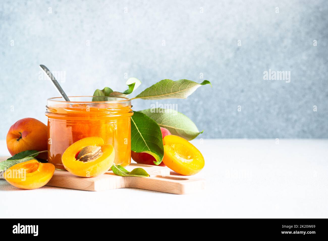 Apricot jam in glass jar at white table Stock Photo - Alamy