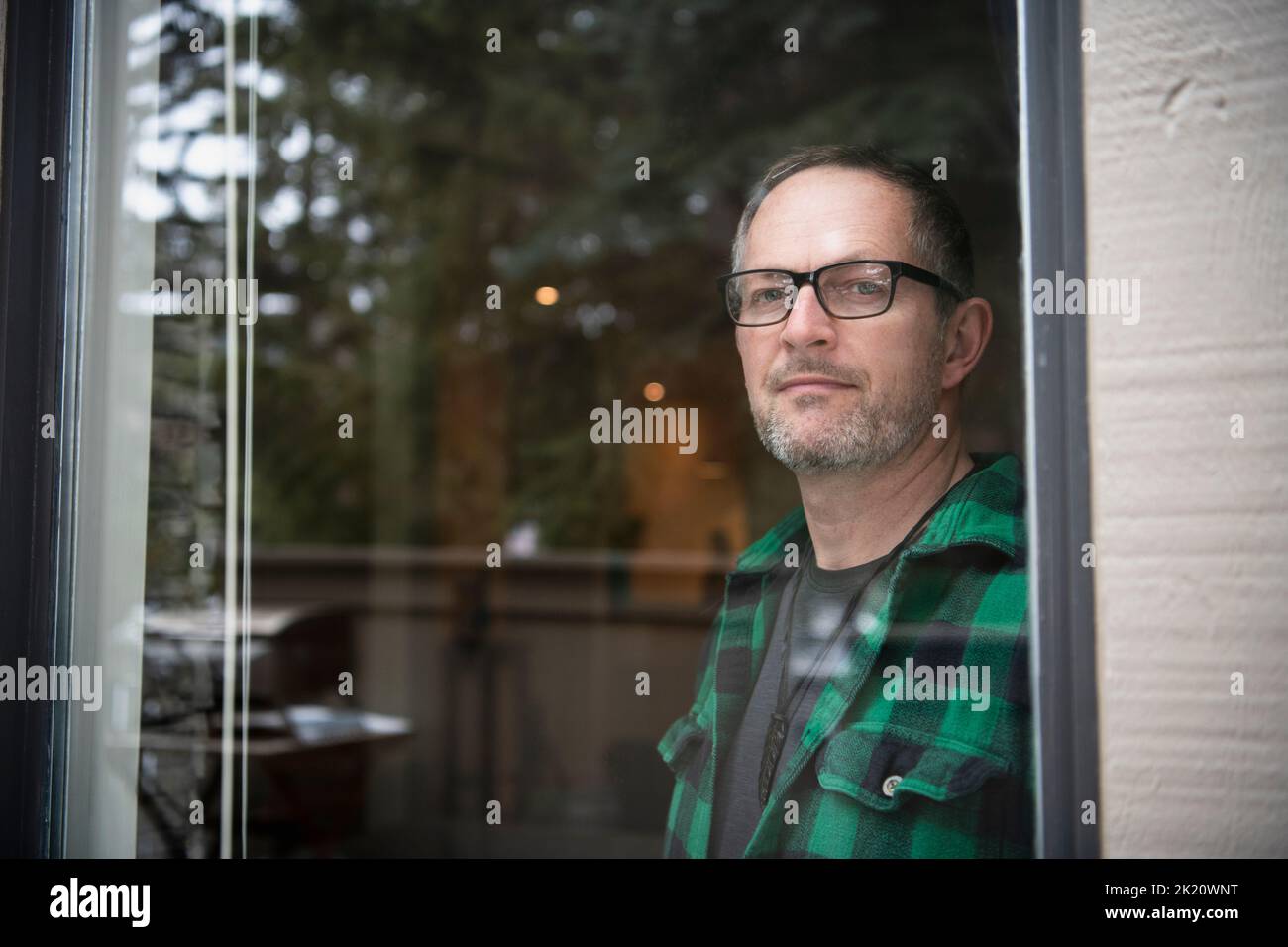 Mature man standing by window hi-res stock photography and images - Alamy