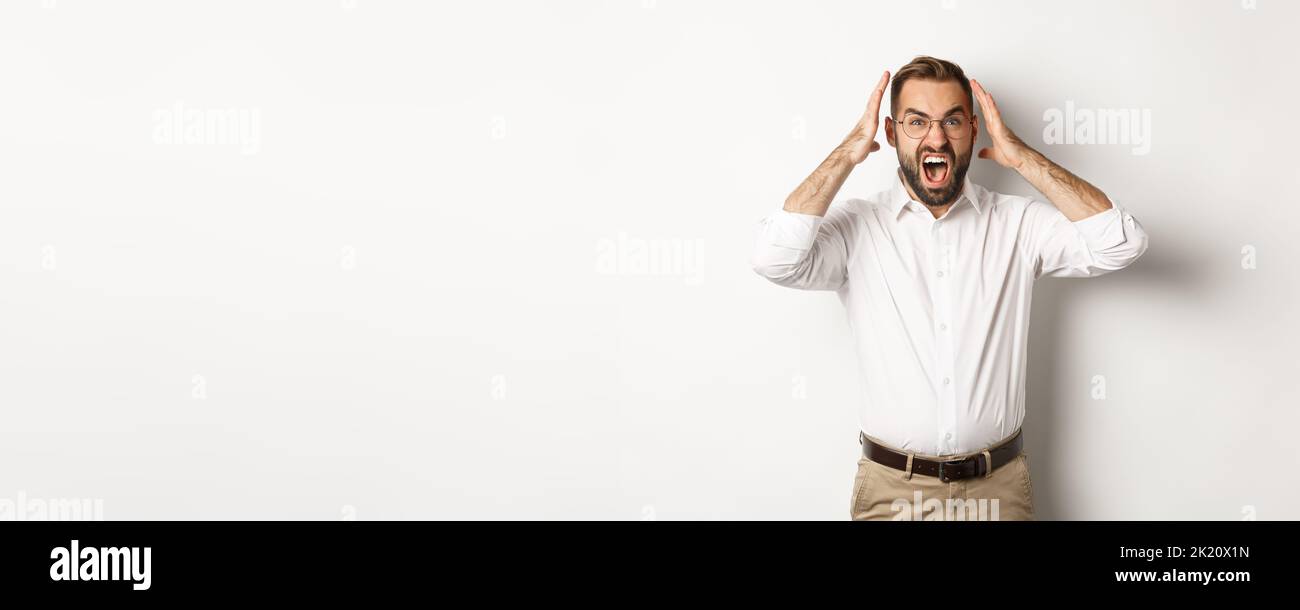 Frustrated man panicking, shouting and looking anxious, standing over ...