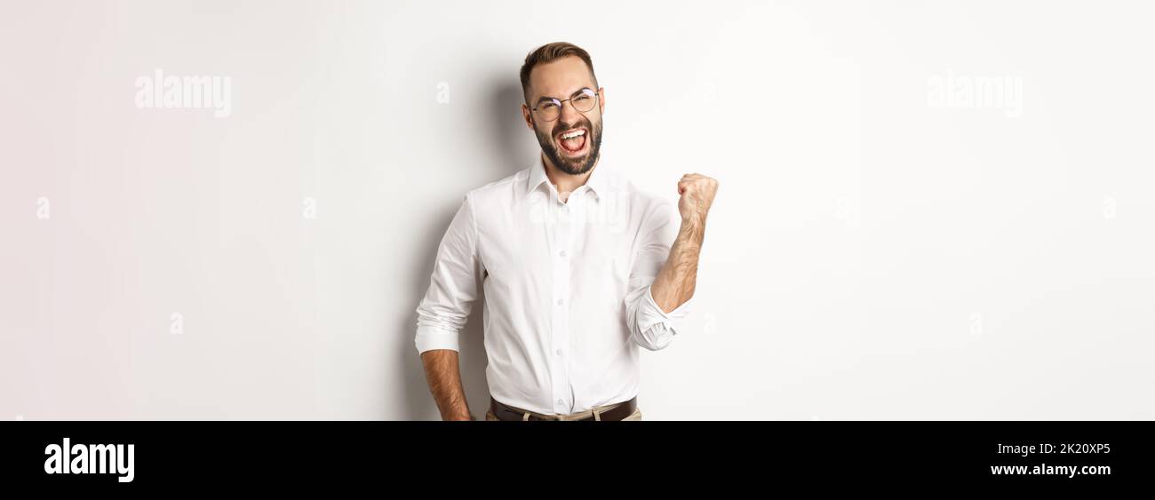 Successful businessman rejoicing, making fist pump and saying yes ...