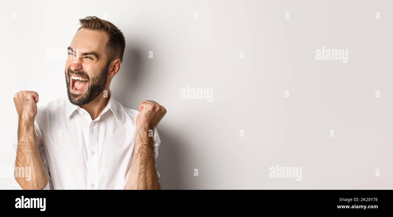 Close-up of successful caucasian man rejoicing, making fist pump and ...