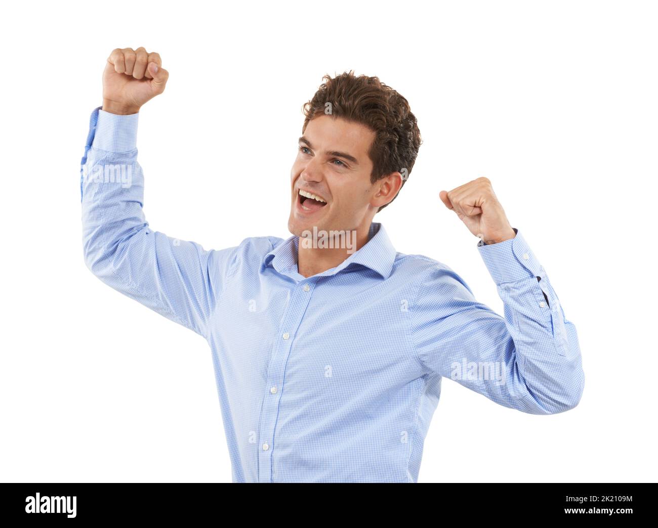 Winning. a handsome young man in a studio raising his arms in ...