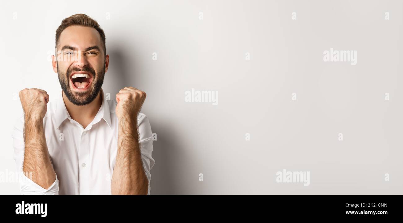 Close-up of successful caucasian man rejoicing of winning, making fist ...