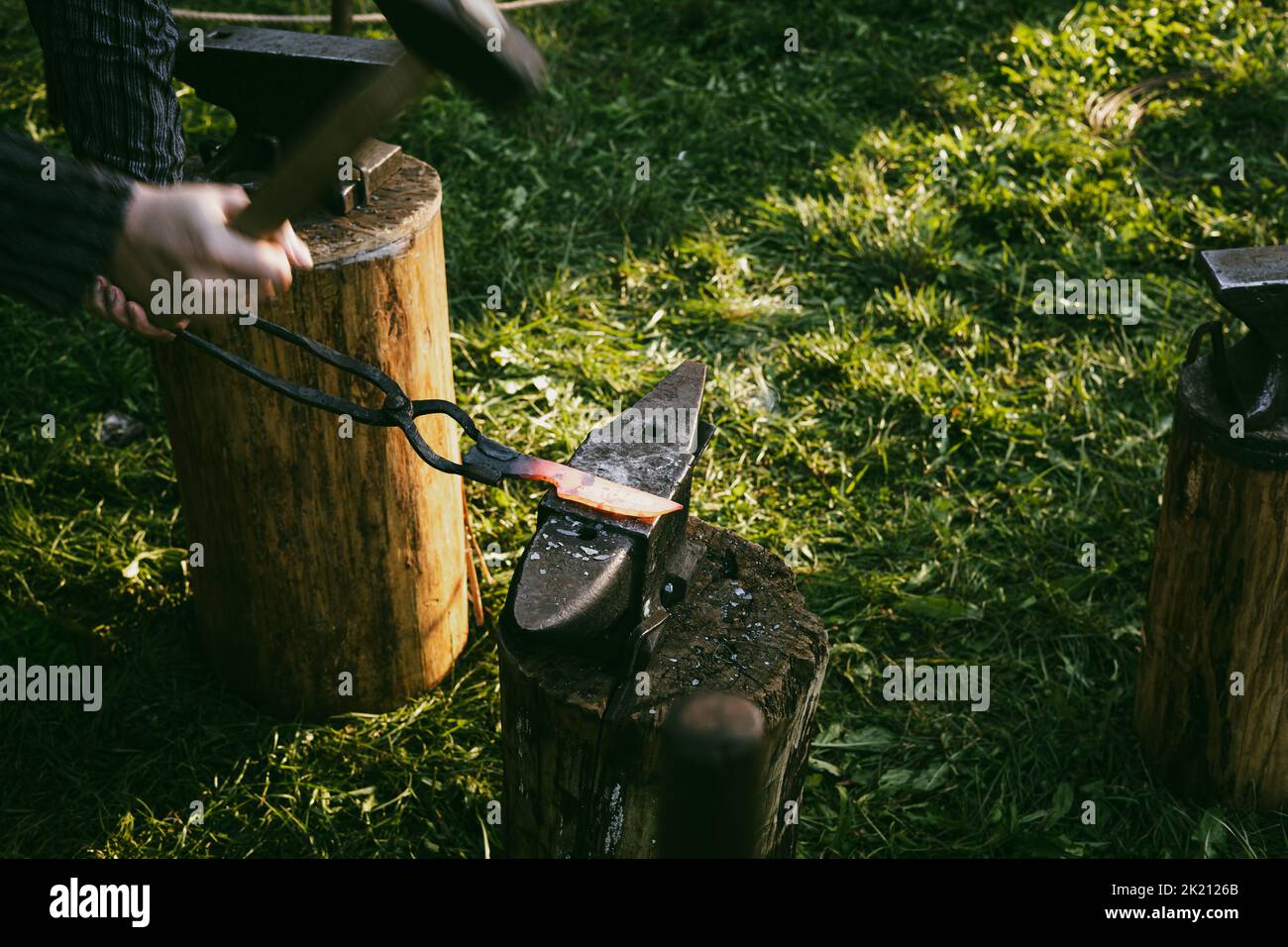 A man forging a knife, blacksmith's workshop in the open air Stock ...