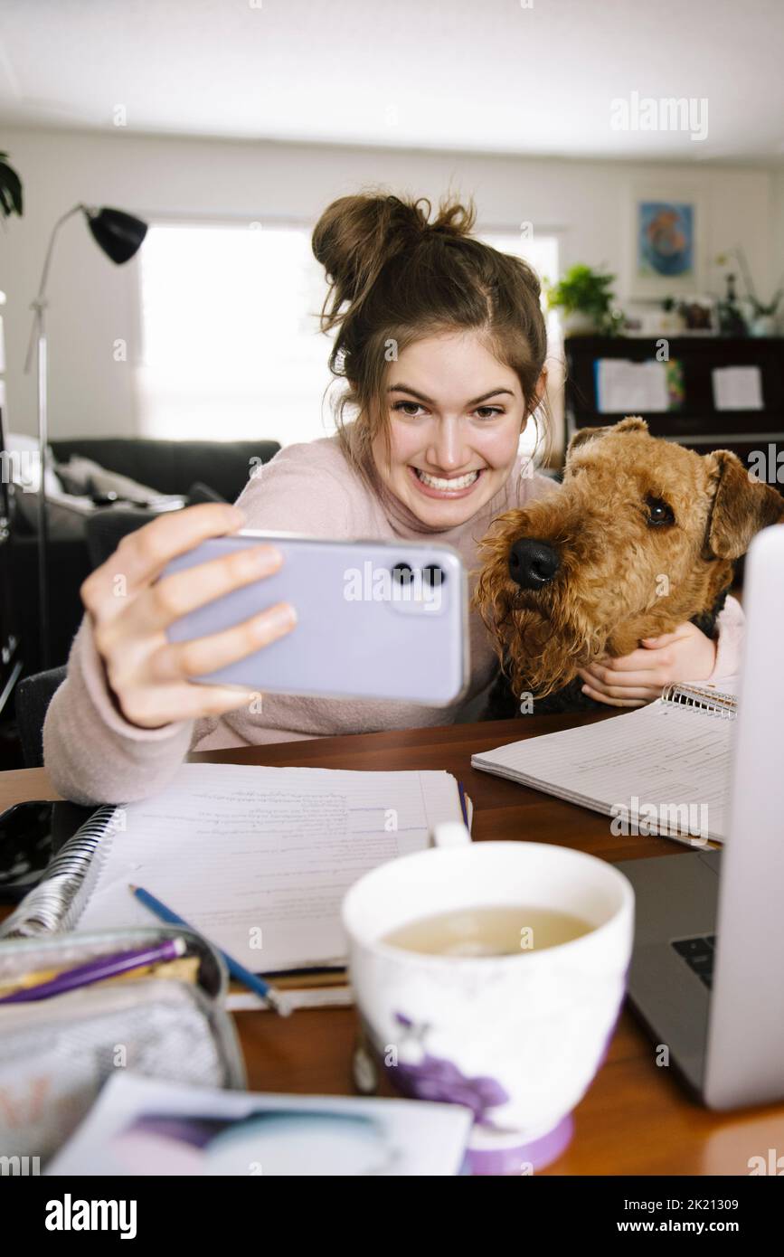 Happy smiling teenage girl and dog taking selfie with smart phone Stock ...