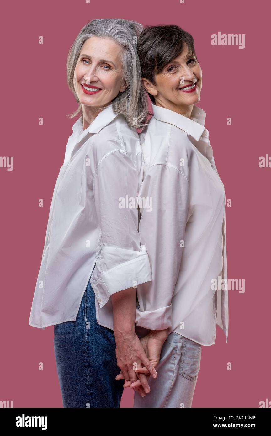 Two women standing back to back hi-res stock photography and images - Alamy