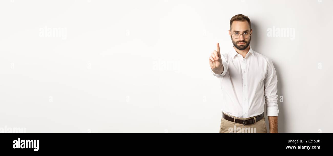 Serious man in glasses showing stop sign, shaking finger to prohibit ...