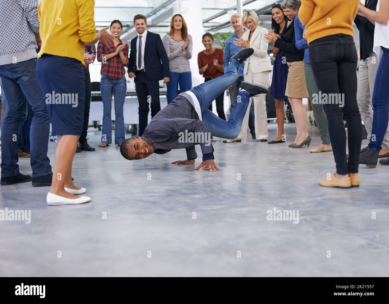 Balancing work and play. a man breakdancing in an office full of ...