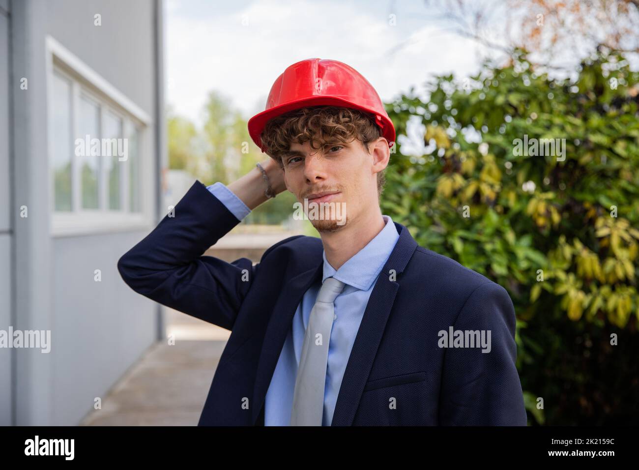 Engineer on construction site wears a safety helmet on his head ...