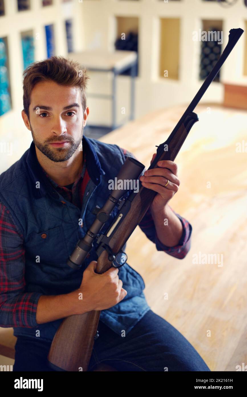 Ready for the hunt. Portrait of a hunter posing with his rifle Stock ...