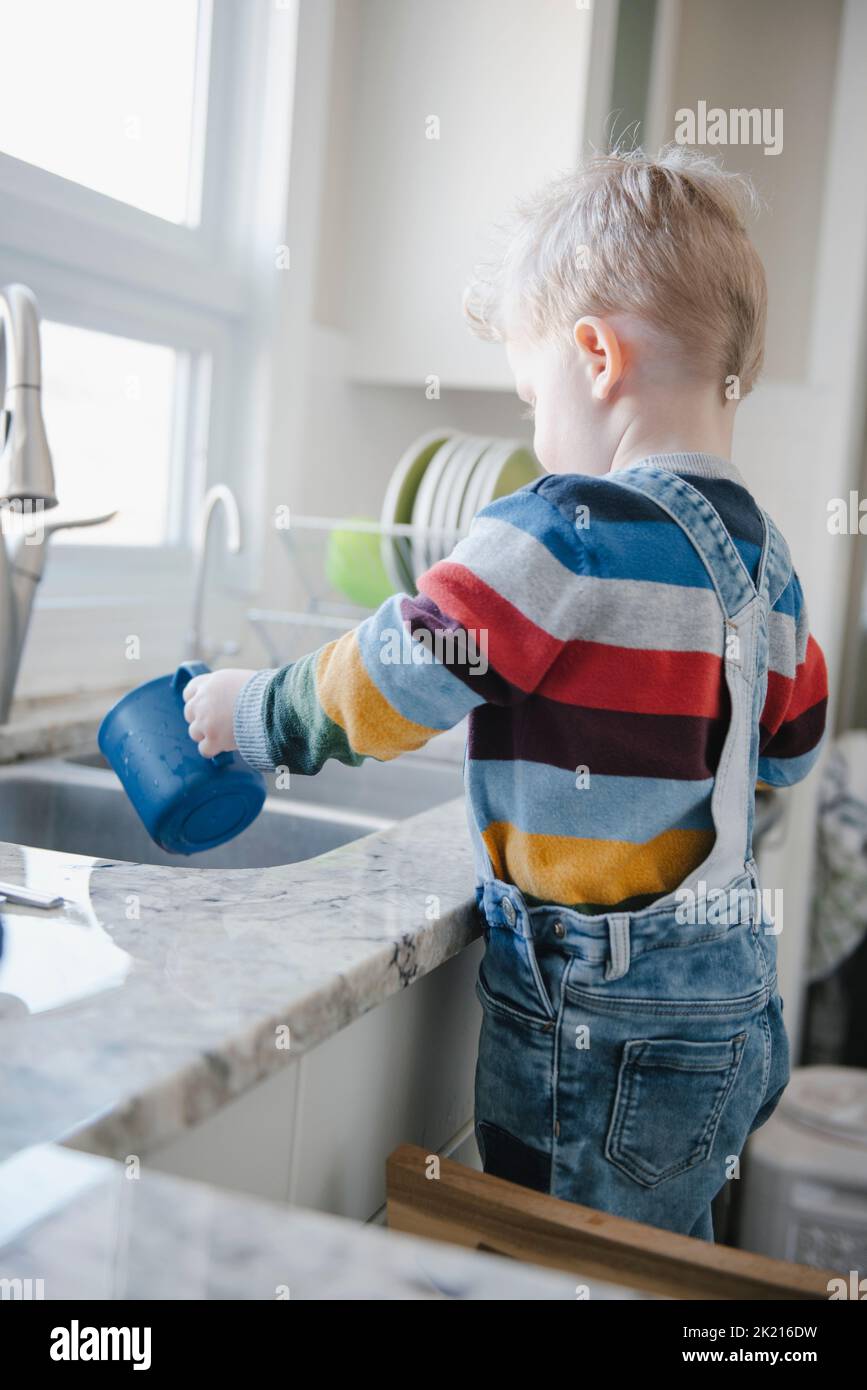 Young boy washing dishes Stock Photo - Alamy