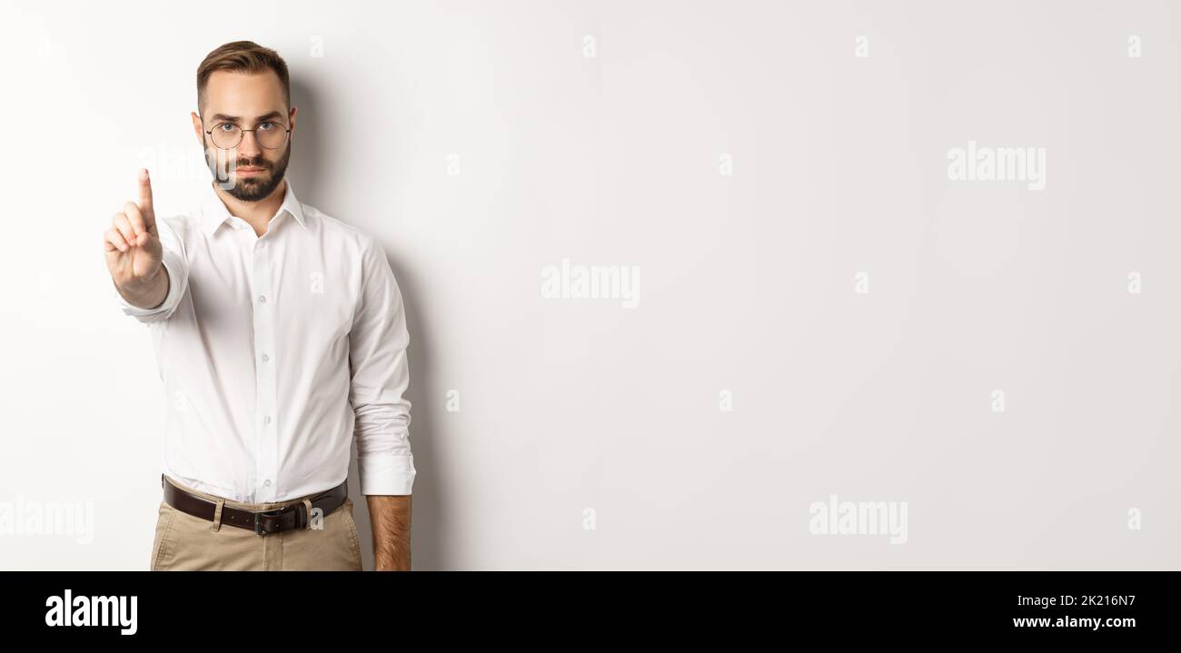 Serious man in glasses showing stop sign, shaking finger to prohibit ...