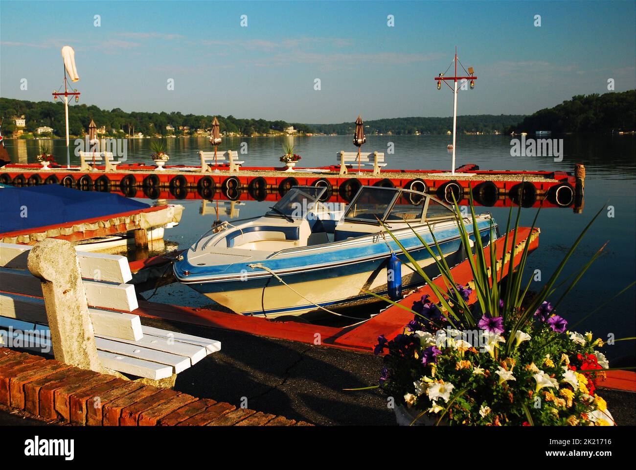 A small pleasure craft boat is tied to the dock at a small marina on a ...