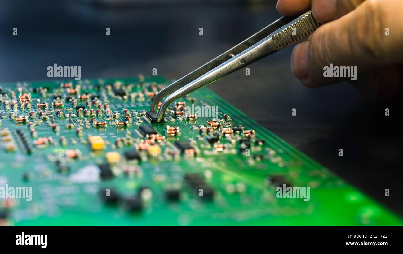 Green printed circuit board with all electric components being repaired ...