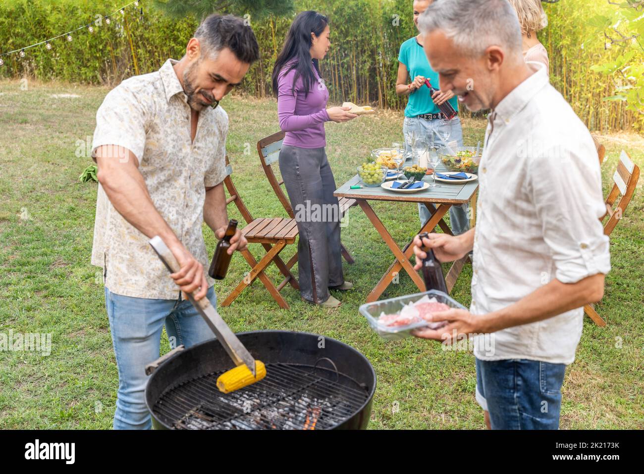 Middle-aged people around the barbecue smiling happy and laughing ...