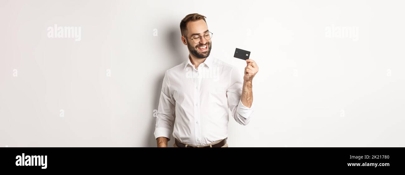 Handsome businessman showing his credit card, looking satisfied ...