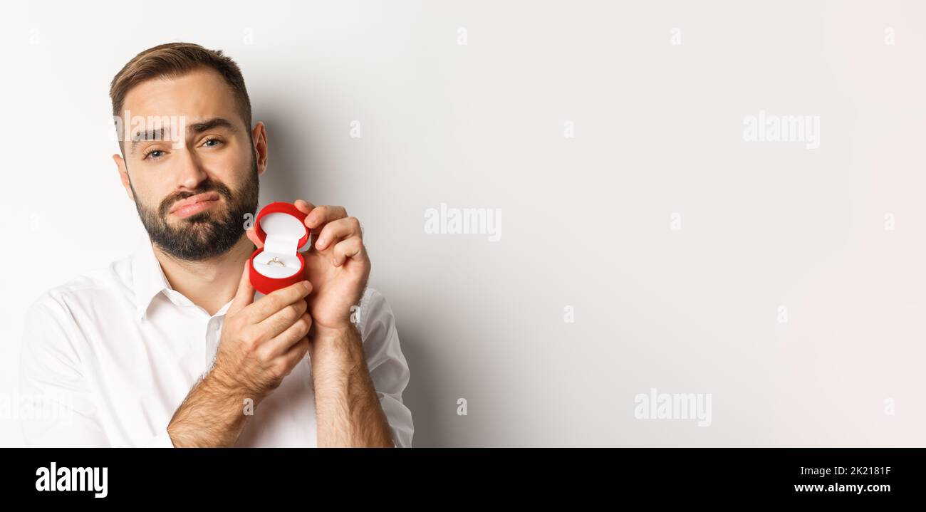 Close-up of hopeful man begging to marry him, looking sad and showing ...