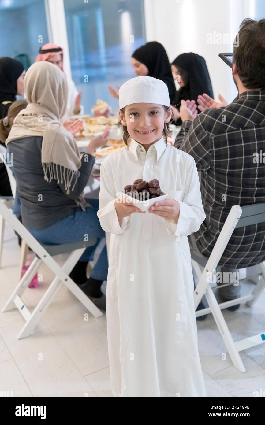 Eid Mubarak Muslim family having Iftar dinner little boy holding a ...