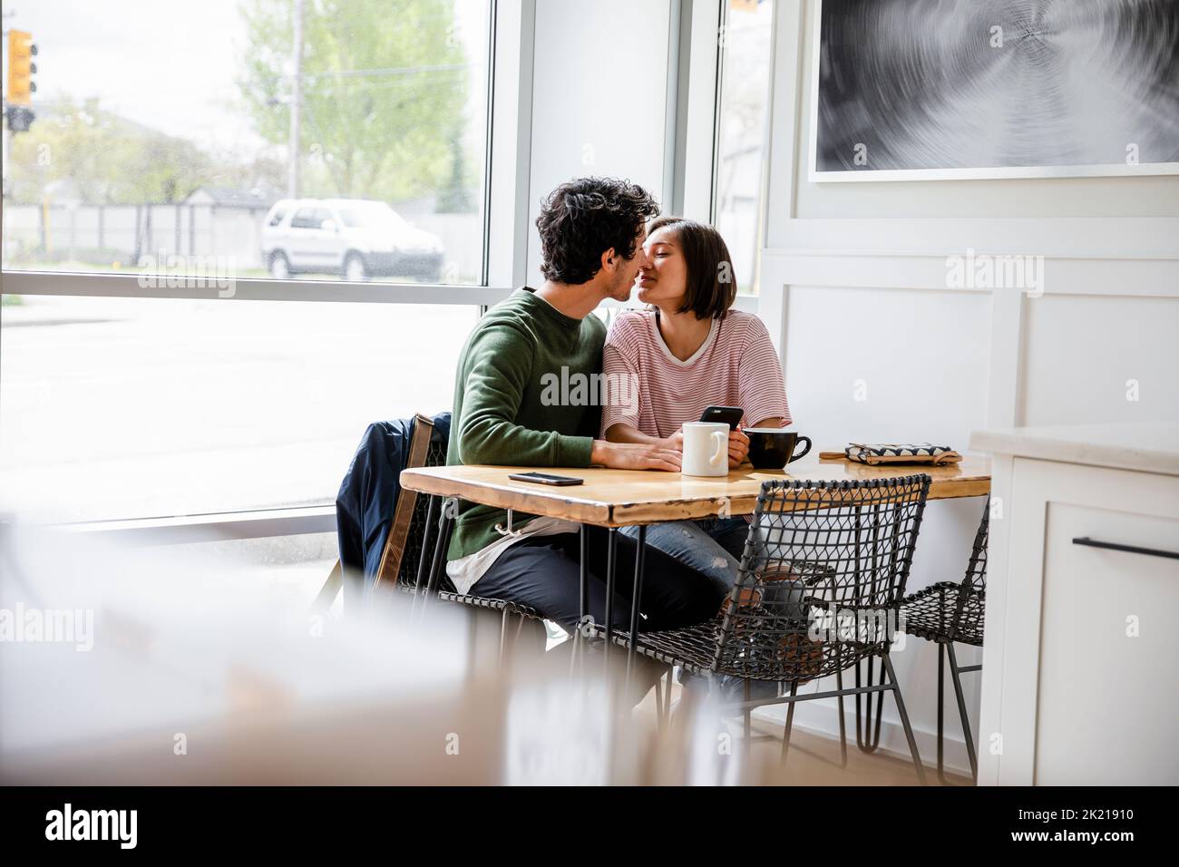 Affectionate couple kissing table hi-res stock photography and images ...