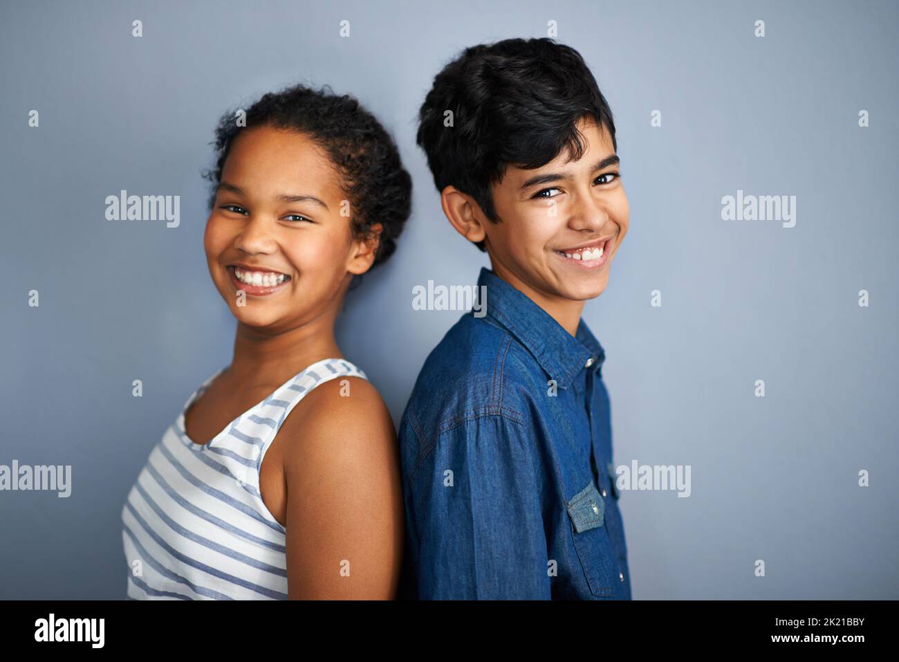 Back to back besties. A cute brother and sister standing isolated on ...