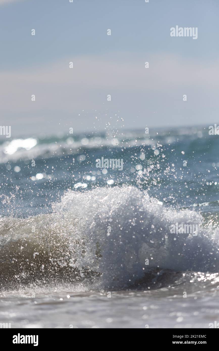 A vertical shot of a foamy wave crashing in the sand - great for ...
